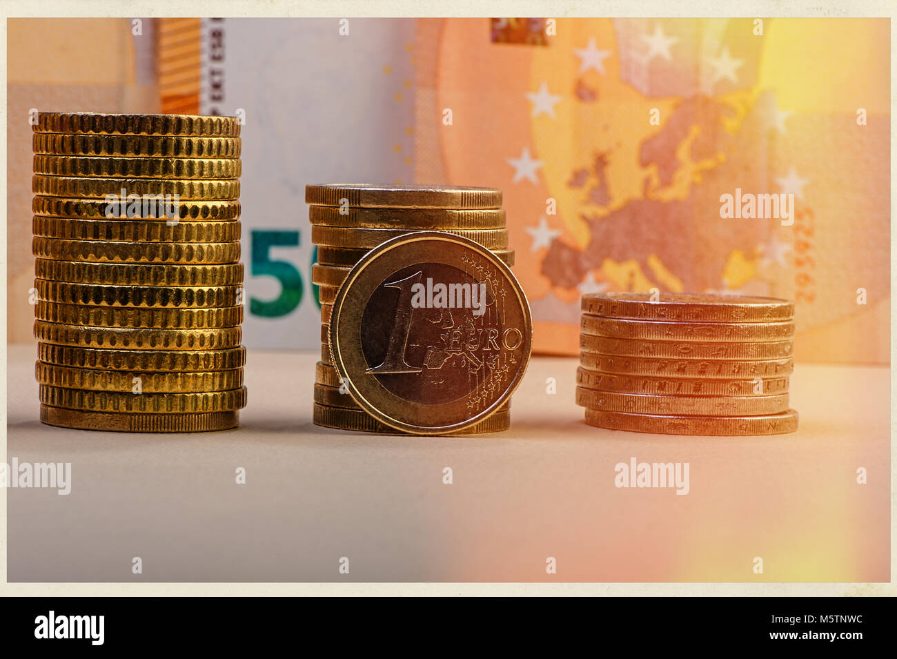 coin of one euro and a stack of folded coins against a background of a ...