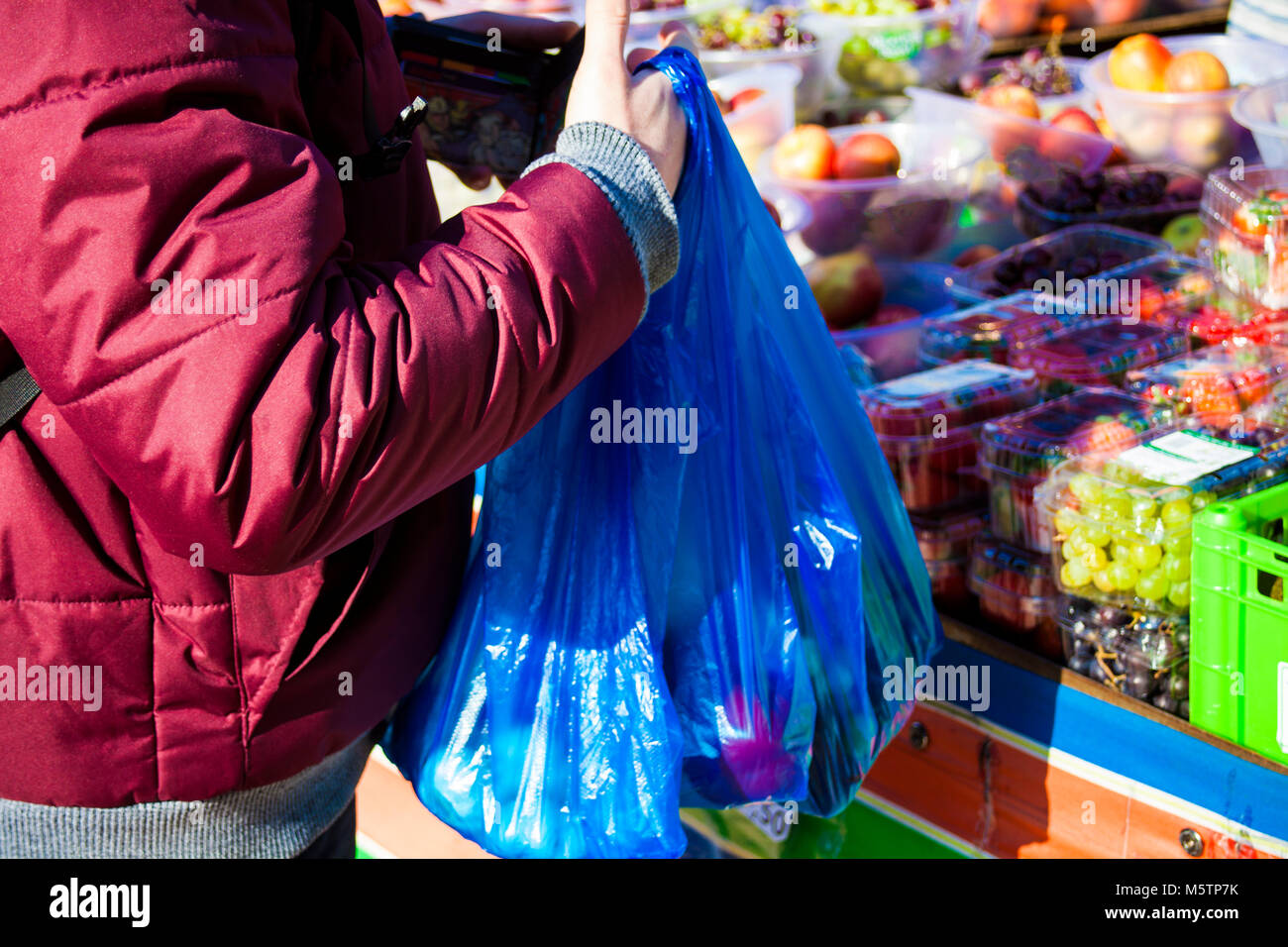 Male consumer at an open street market shopping fruit and vegetables ...