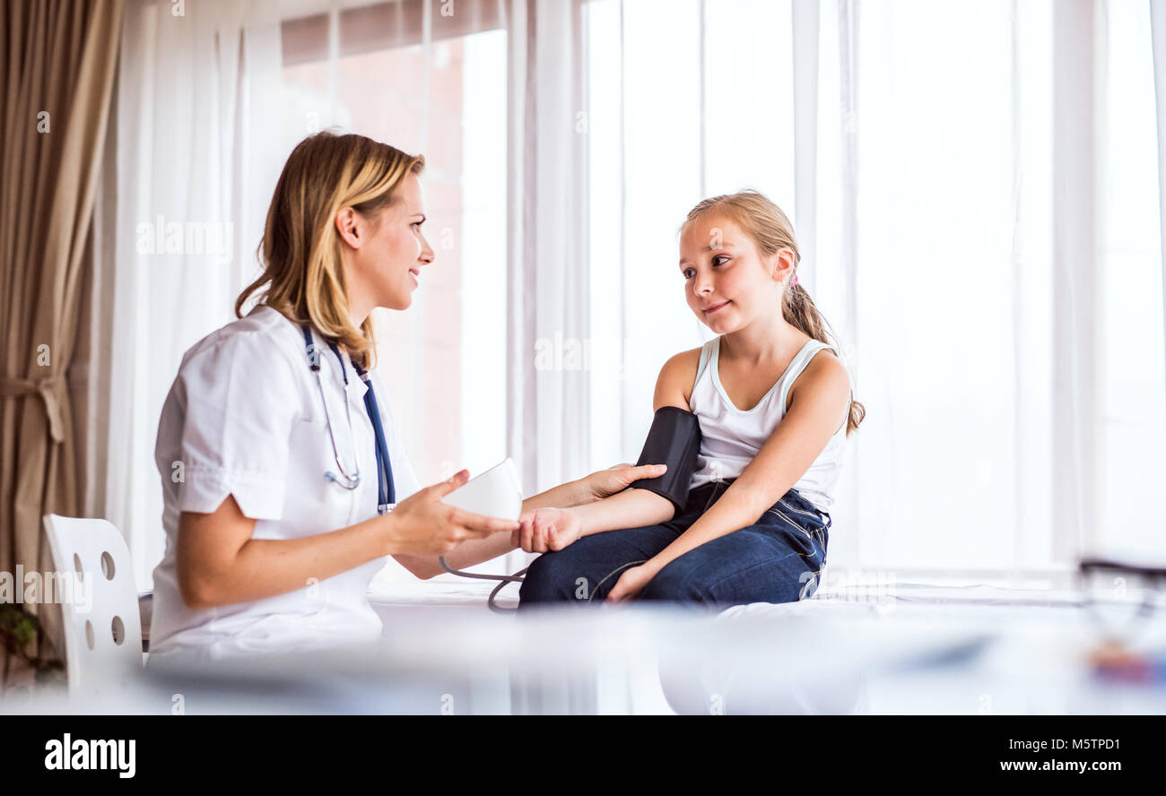 Young female doctor checking a small girl in her office Stock Photo - Alamy