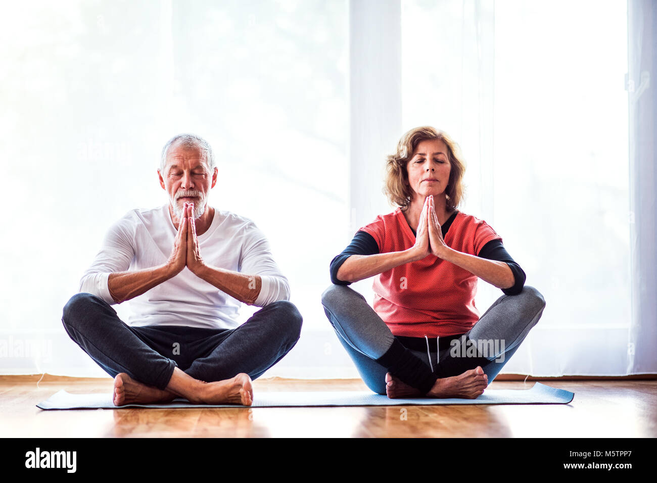 Senior couple meditating at home Stock Photo - Alamy