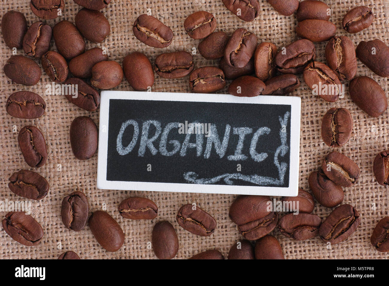 Roasted organic coffee beans and the word Organic. Close up Stock Photo ...