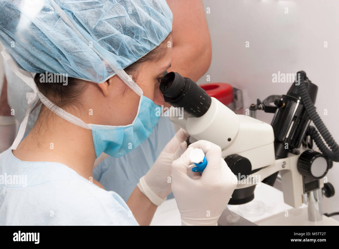 Medical professional looking through a microscope Stock Photo - Alamy