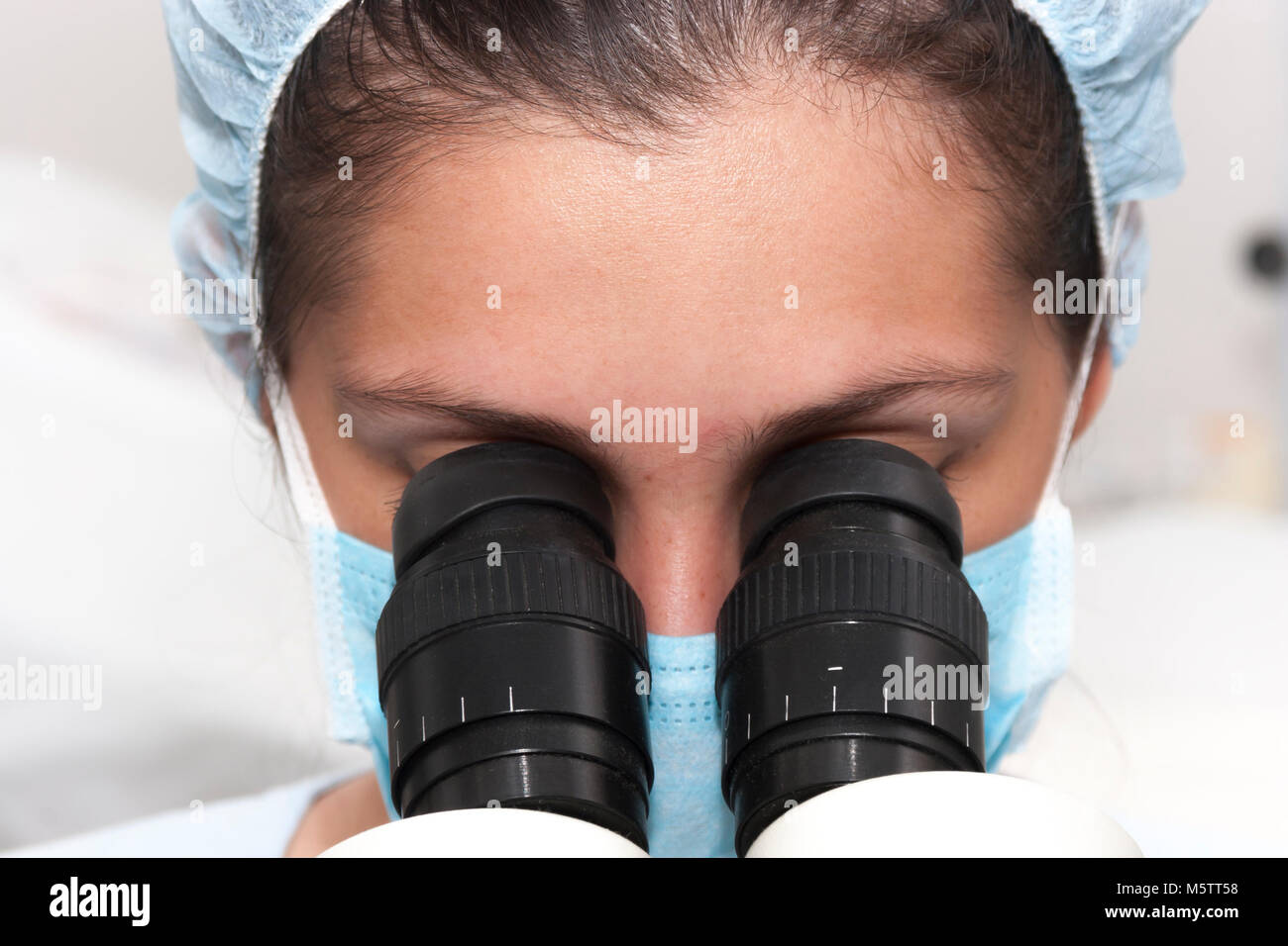 Medical professional looking through a microscope Stock Photo - Alamy