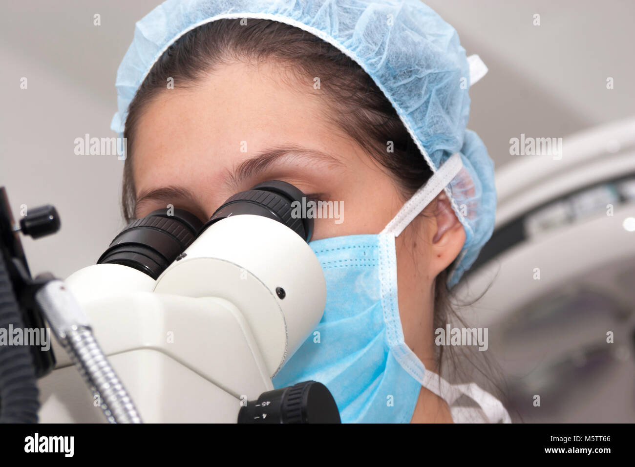 Medical professional looking through a microscope Stock Photo - Alamy