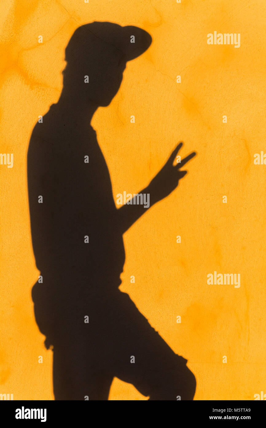 Teenager boy's shadow on yellow textured wall with attitude abstract ...