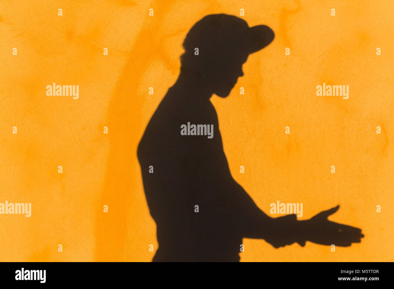 Teenager boy's shadow on yellow textured wall with attitude abstract ...