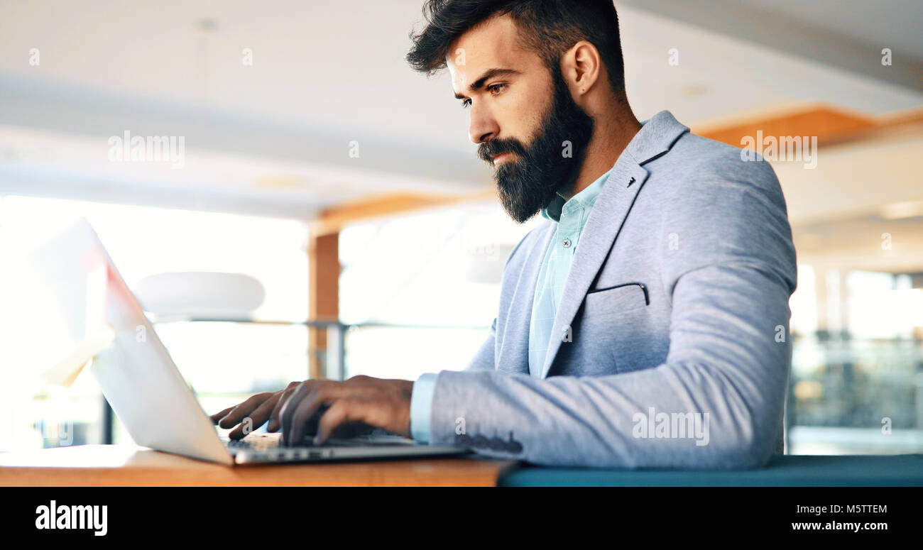 Professional businessman working on laptop in office Stock Photo - Alamy