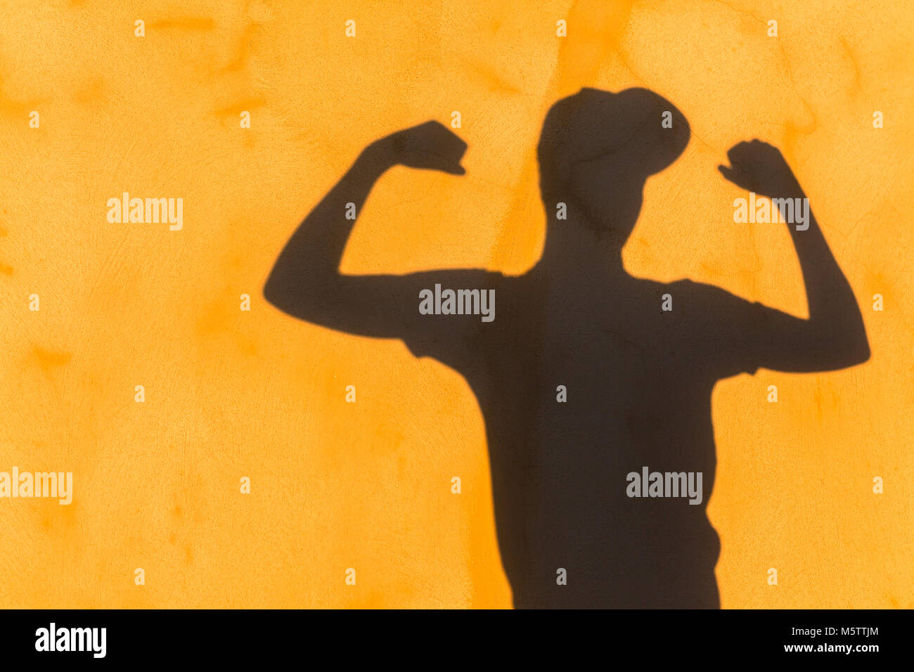 Teenager boy's shadow on yellow textured wall with attitude abstract ...