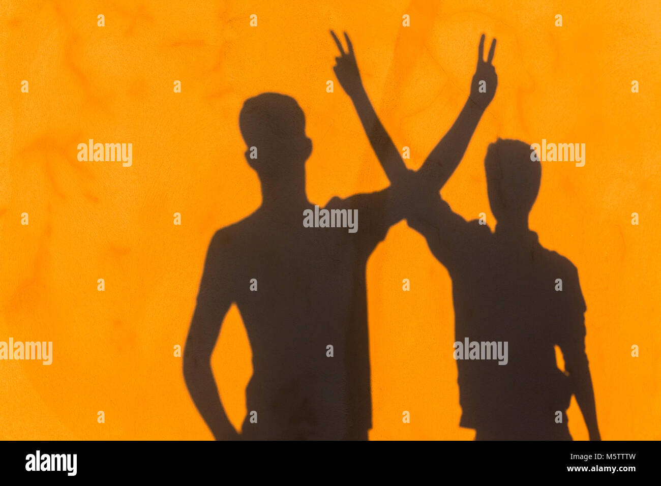 Teenager boy's shadow on yellow textured wall with attitude abstract ...