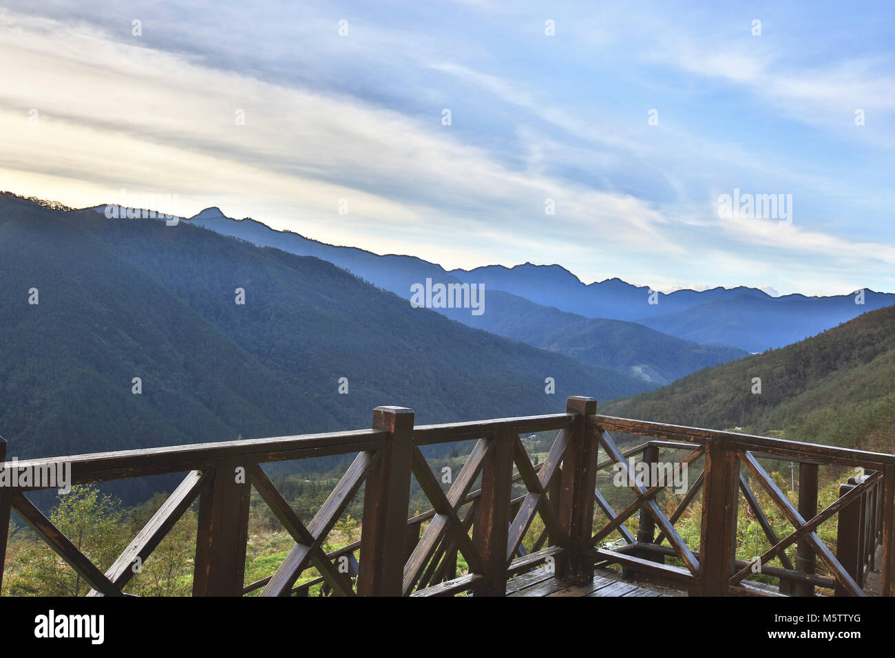 Beautiful mountain landscape with wooden viewing platform and railing ...
