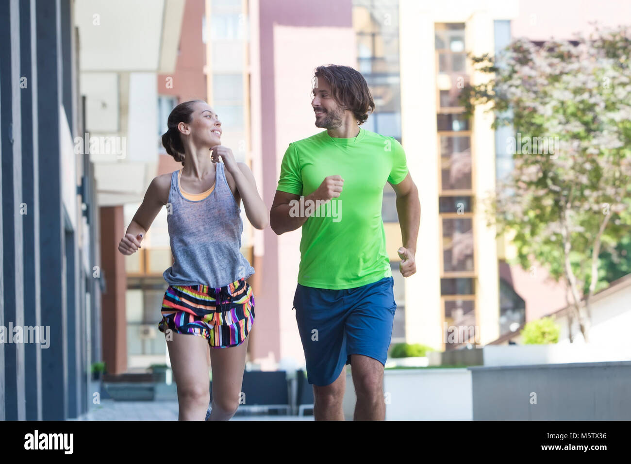 Couple running in urban enviroment at hot summer day Stock Photo - Alamy