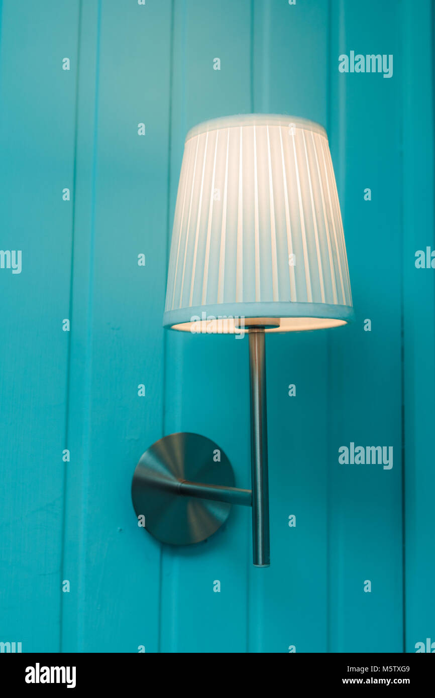 Blue wall with a wall mounted Lamp Stock Photo - Alamy