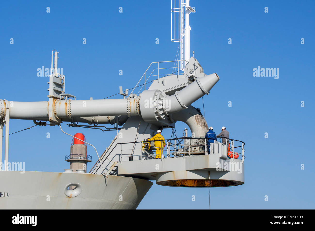Workers on bow connection platform of trailing suction hopper dredger ...