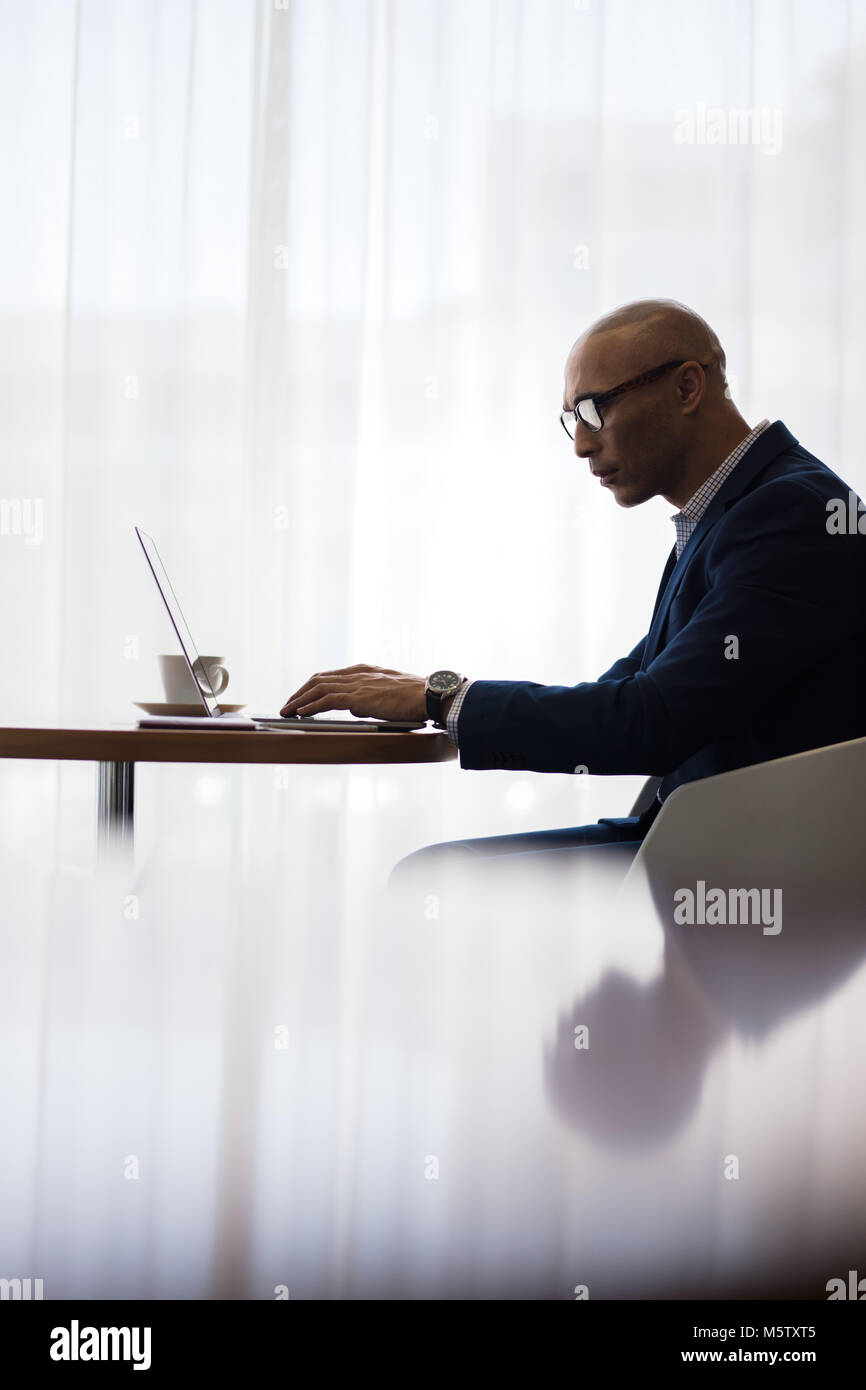 Side view of a male office worker looking at wire mess connecting ...