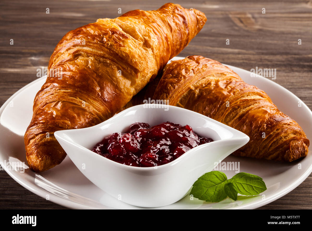 Croissant with jam on wooden background Stock Photo - Alamy