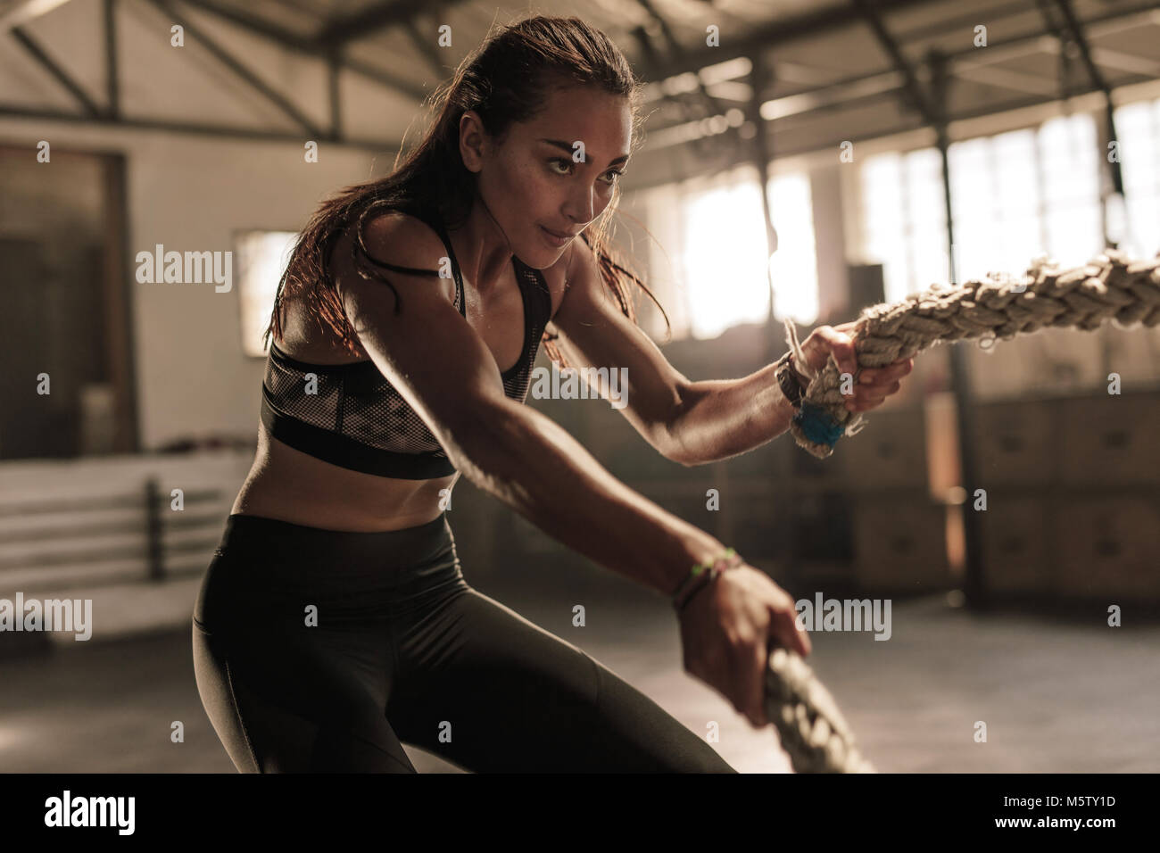 fitness woman using battle ropes for exercising. Female working out ...