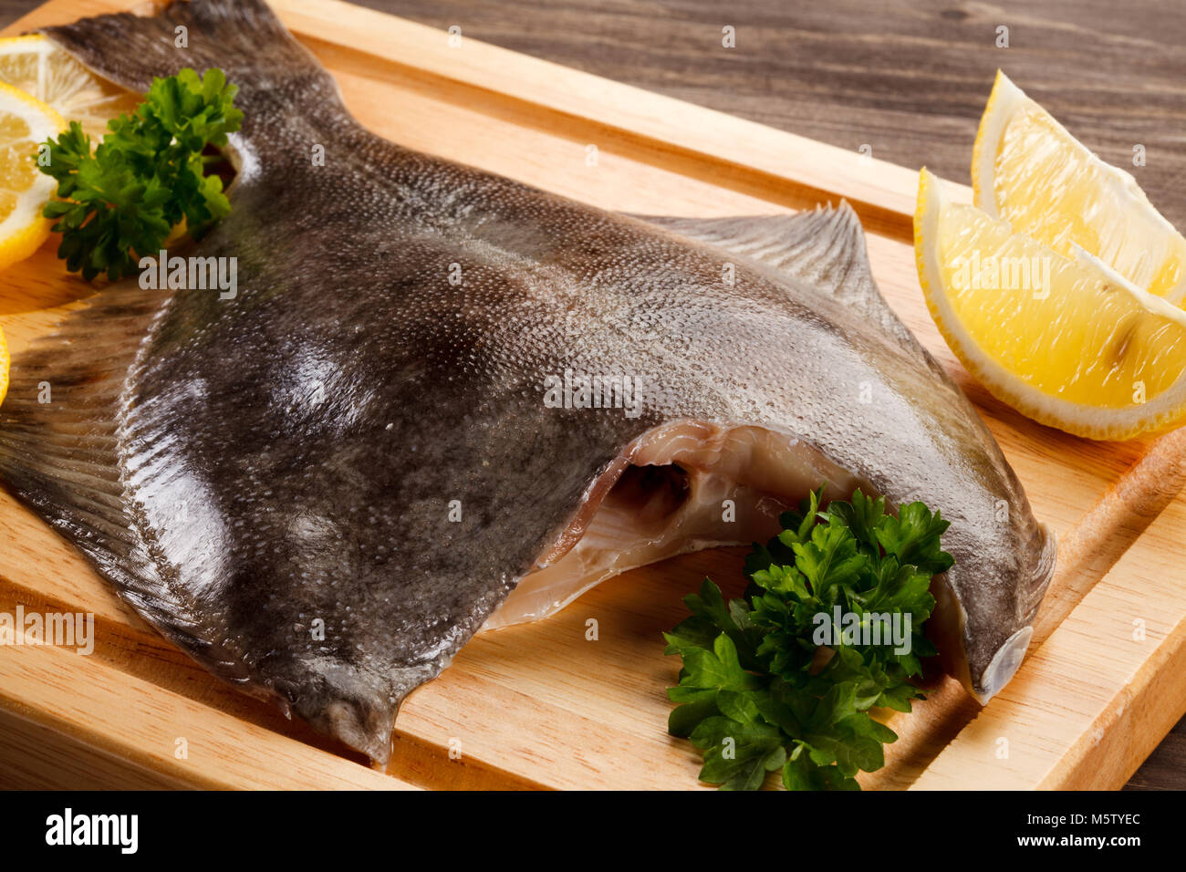 Fresh raw flounder on cutting board Stock Photo - Alamy