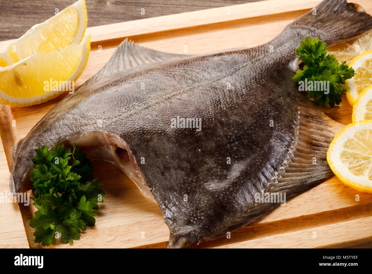 Fresh raw flounder on cutting board Stock Photo - Alamy