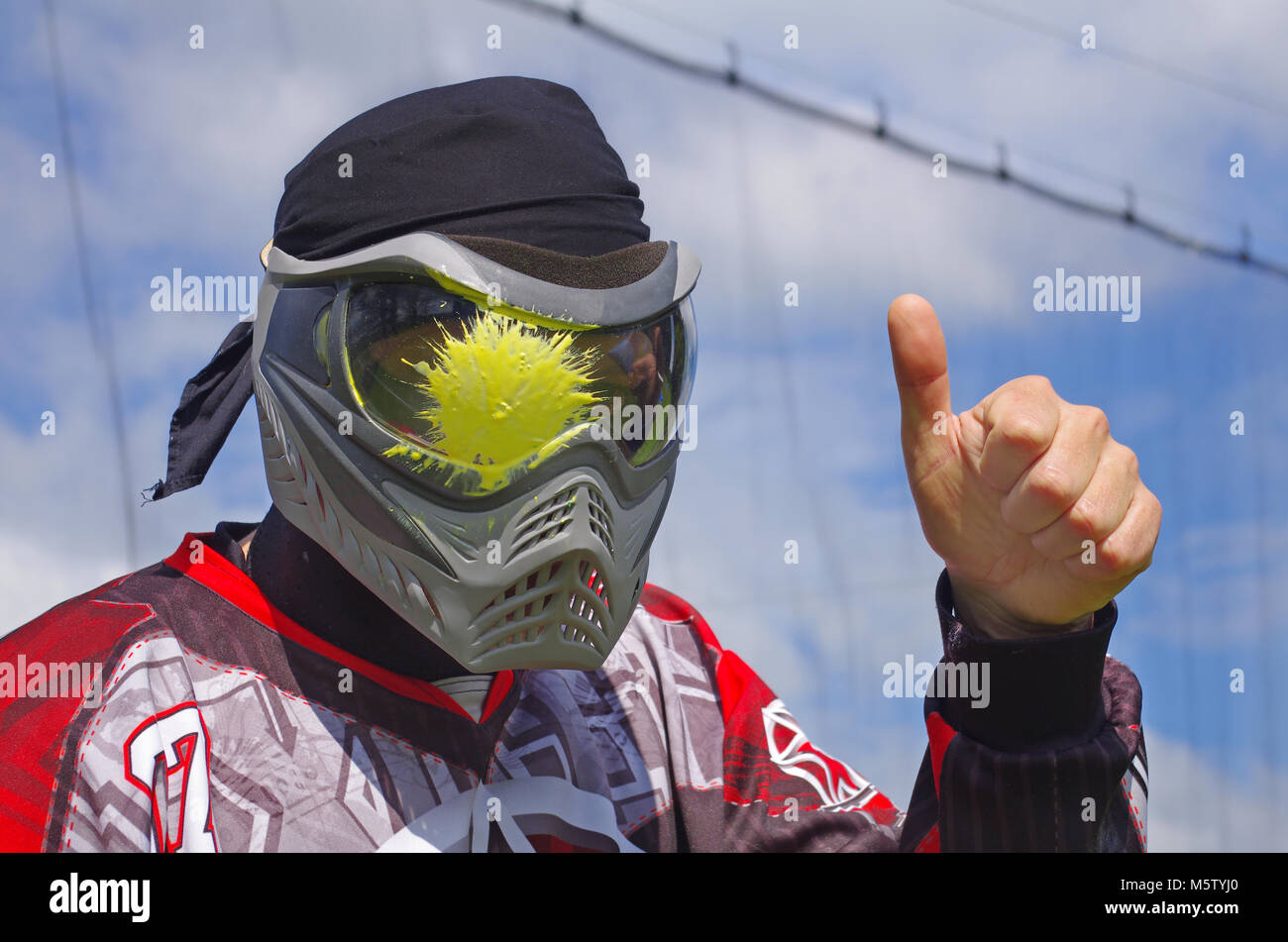 Paintball sport player with head shot by paint spot Stock Photo - Alamy