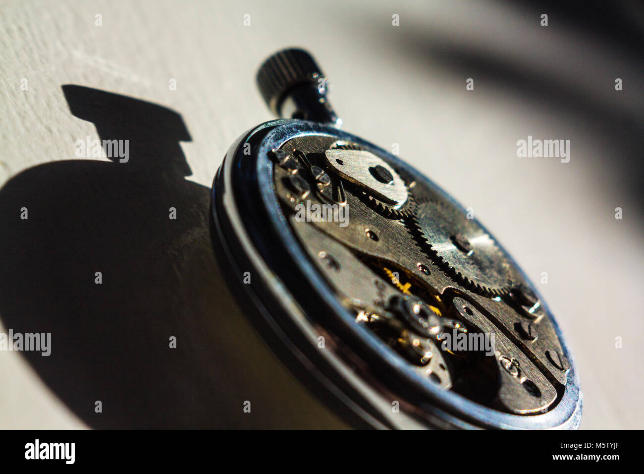 Open back of old pocket watch with sidelight and contrasting shadow ...
