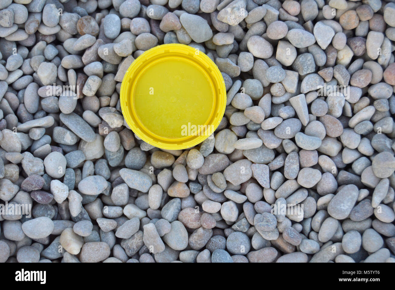 stone background with a big yellow plastic plug Stock Photo - Alamy