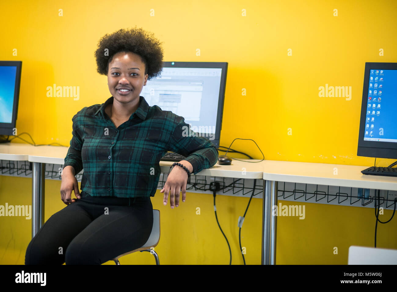 a young black international student is photographed using a computer in ...