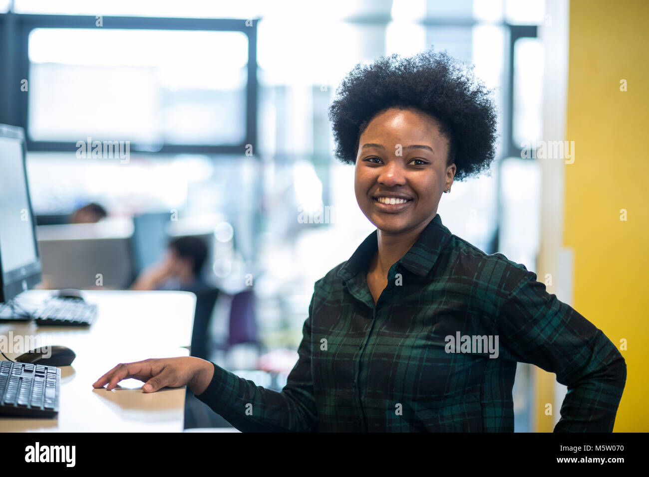 a young black international student is photographed using a computer in ...