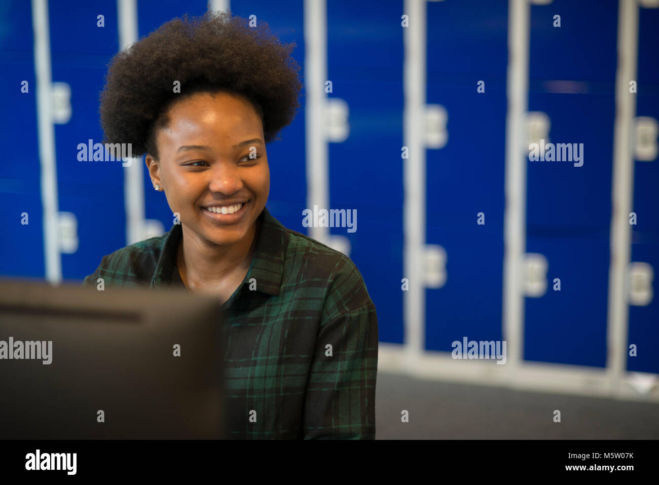 a young black international student is photographed using a computer in ...