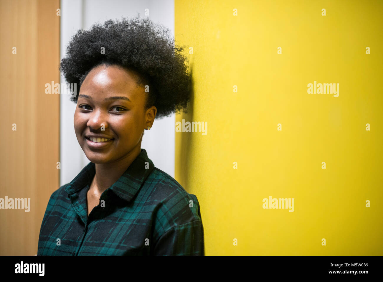 a young black student has her portrait taken in the college hallway ...