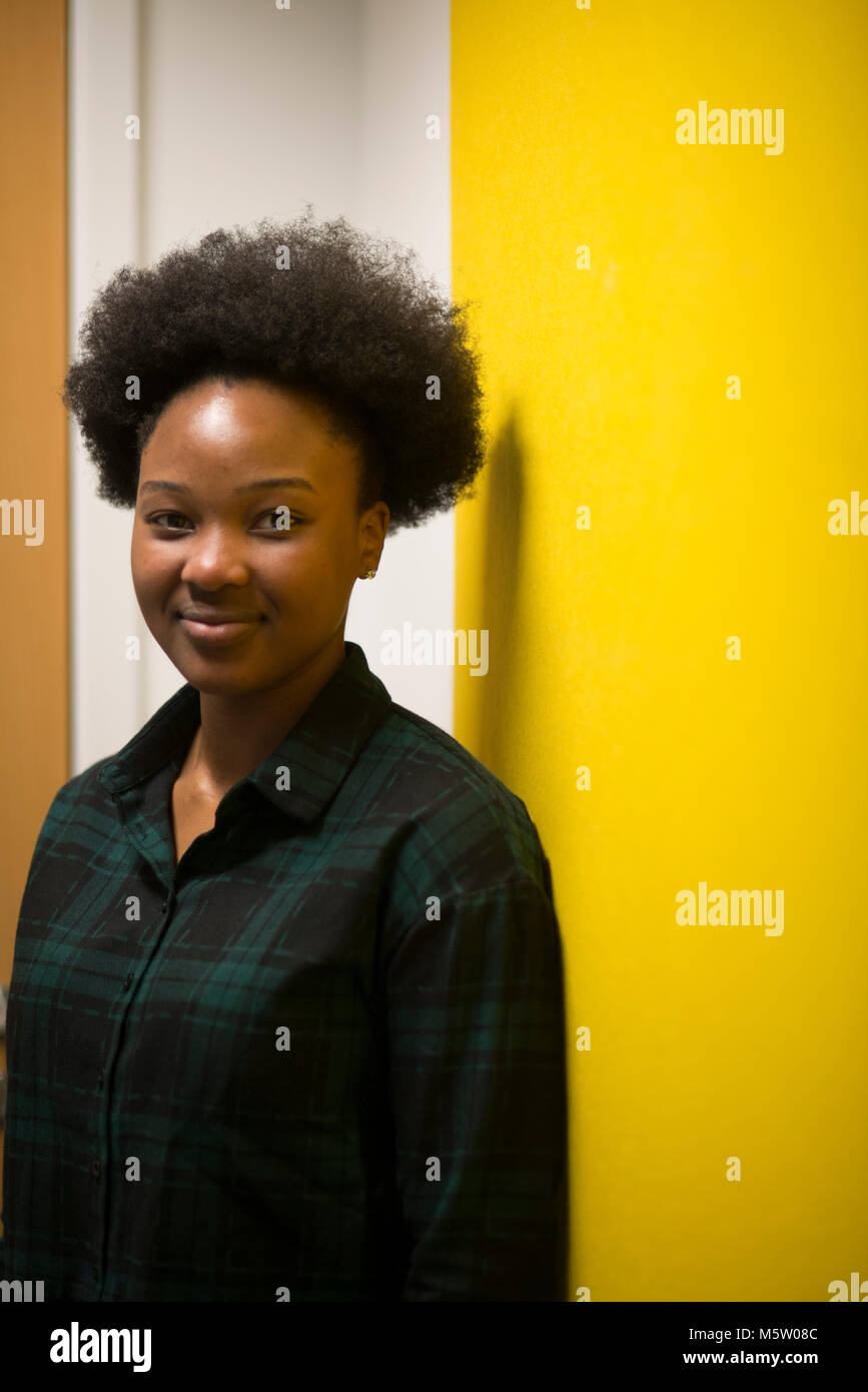 a young black student has her portrait taken in the college hallway ...