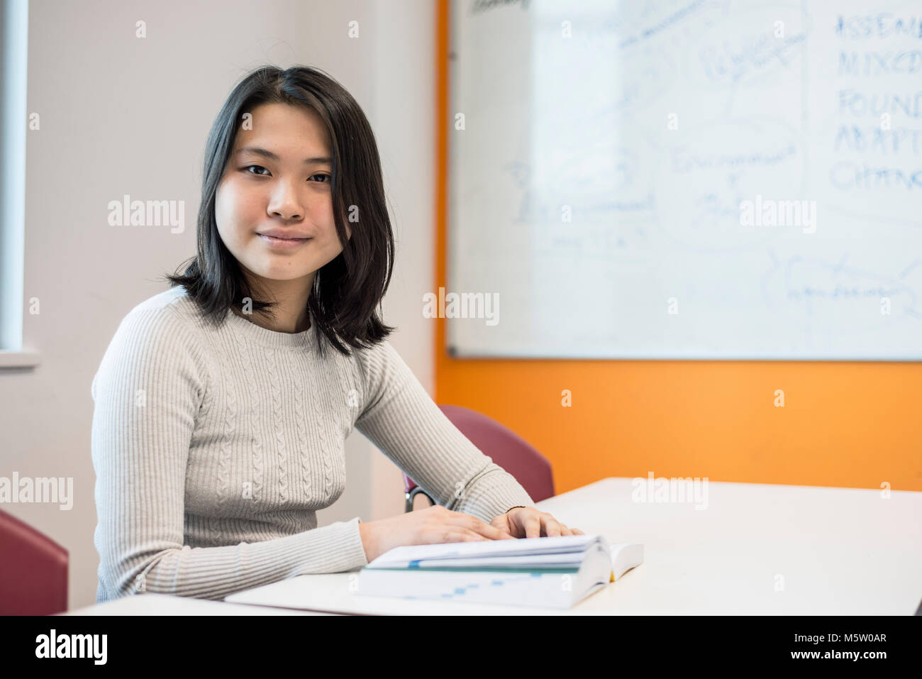 a young international asian english student in her classroom at college ...