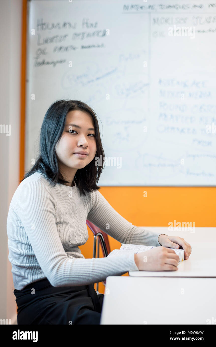 a young international asian english student in her classroom at college ...