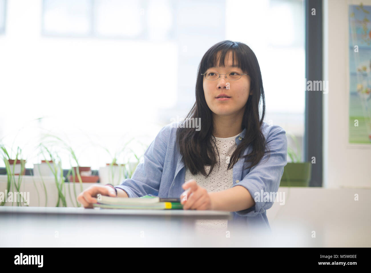 a young international asian english student in her classroom at college ...