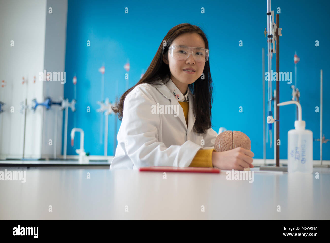 a young international asian student is photographed in the science lab ...