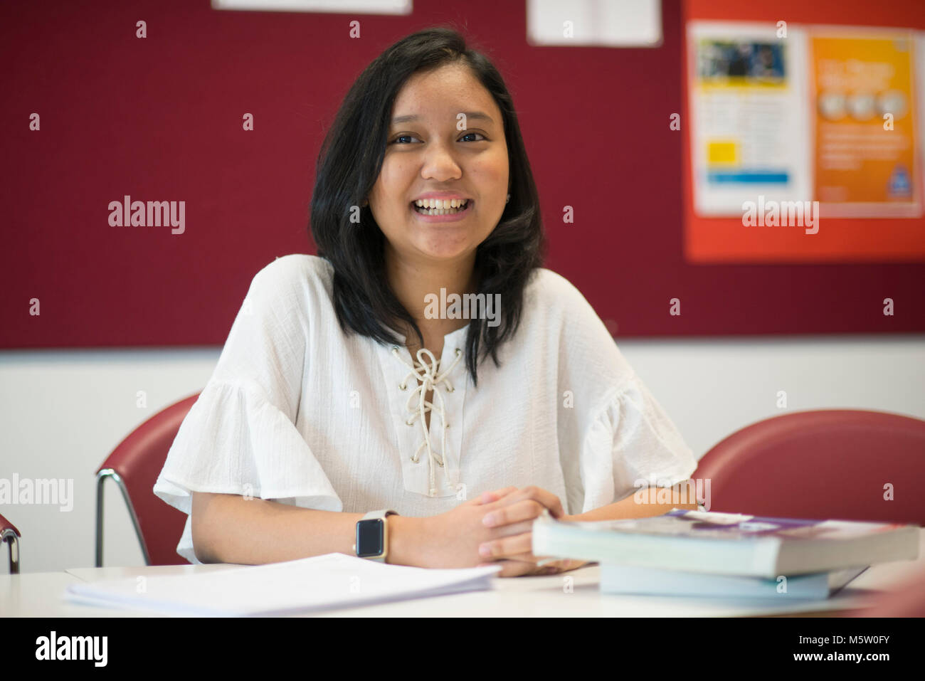 a young international asian english student in her classroom at college ...