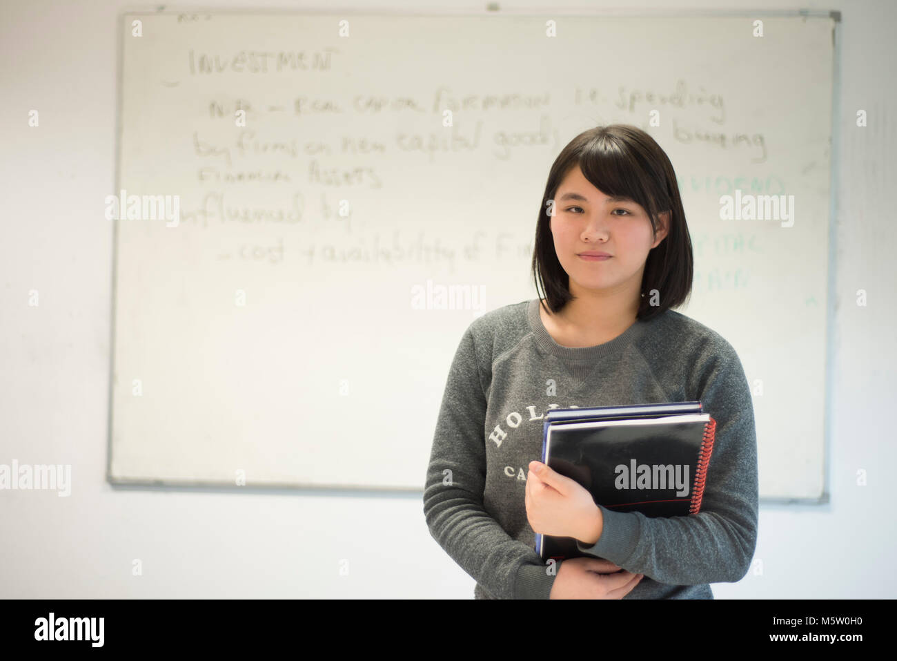 a young international asian english student in her classroom at college ...