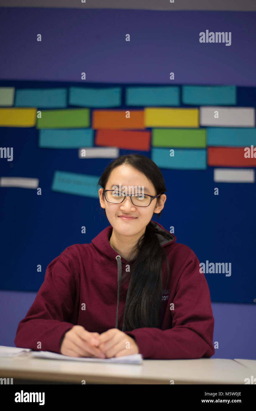 an asian female international student sits in a classroom on college ...