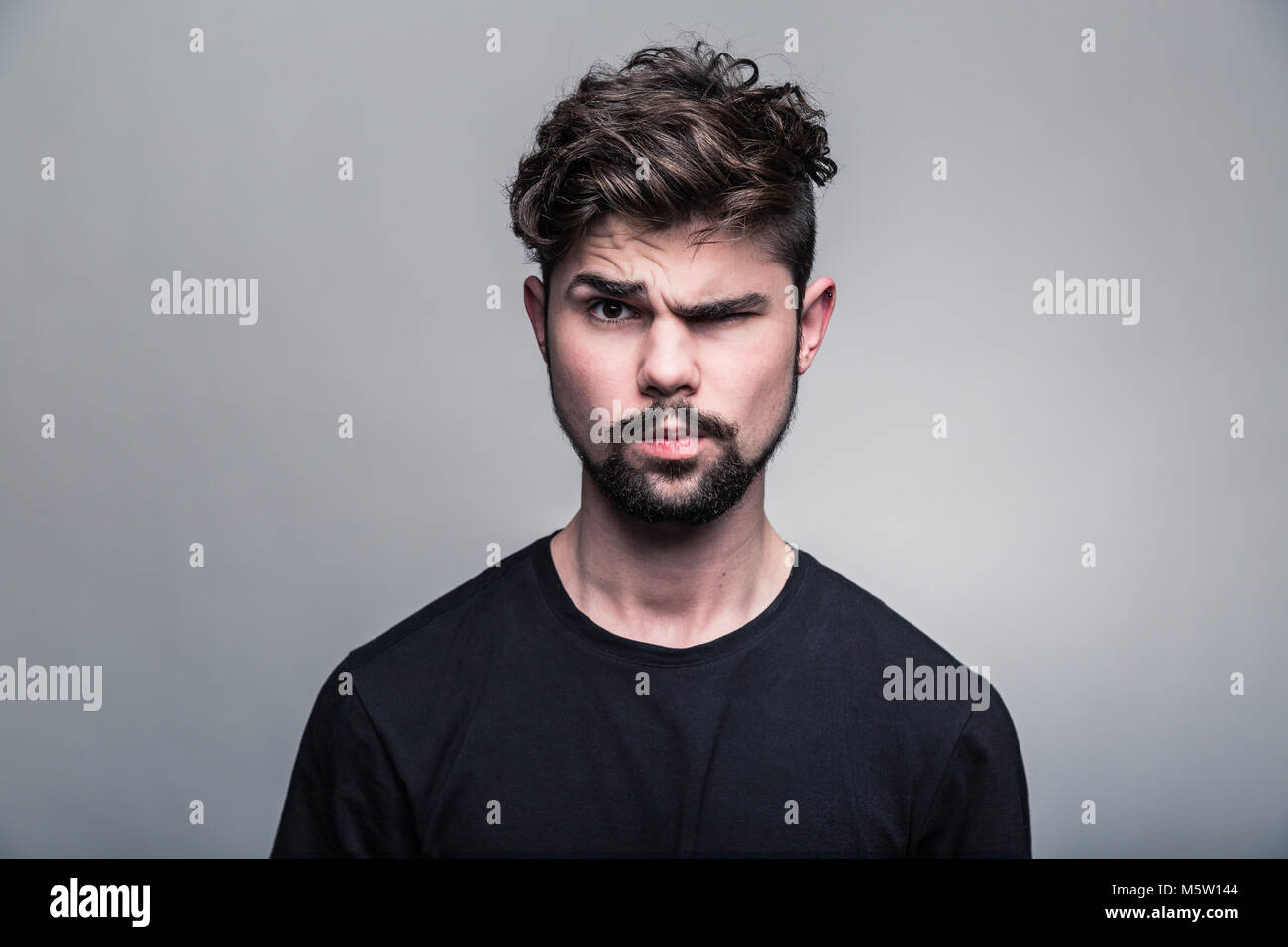 young handsome man doubting isolated over gray background Stock Photo ...