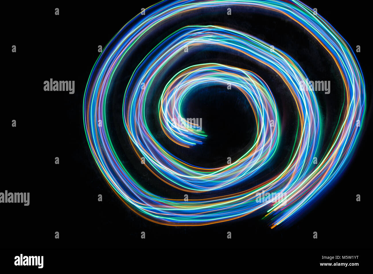 The vortex shape digital neon lights are on the dark background Stock ...