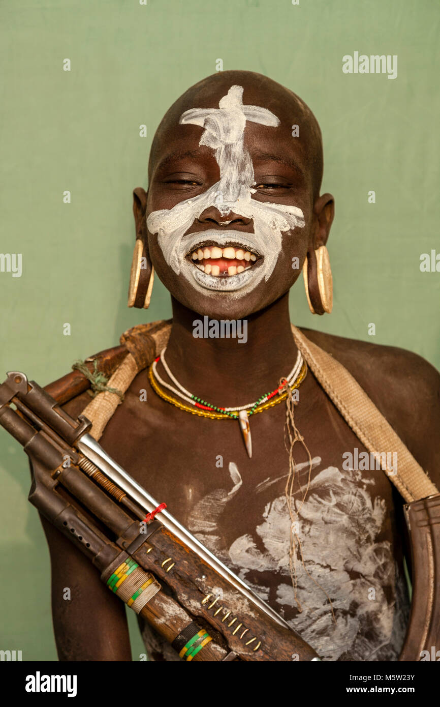 A Portrait Of A Boy From The Mursi Tribe Holding A Gun, Mursi Village ...