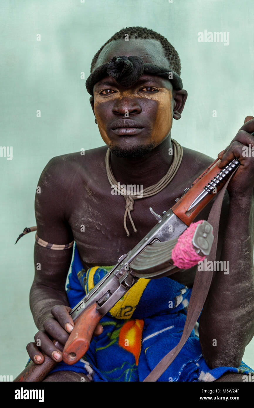 A Portrait Of A Young Man From The Mursi Tribe Holding A Gun, Mursi ...