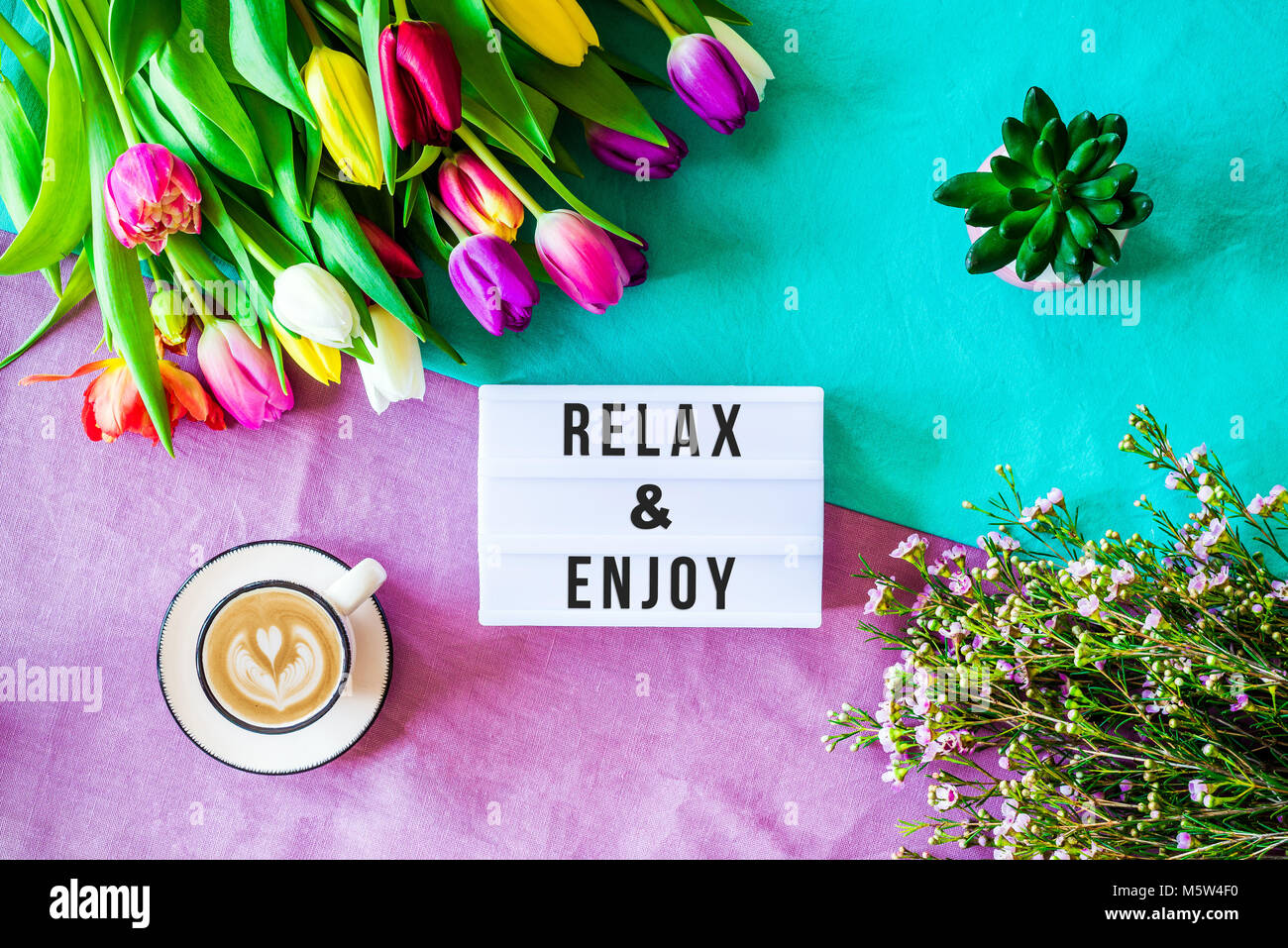 Shot from above as flatlay with relax & enjoy message written on light ...