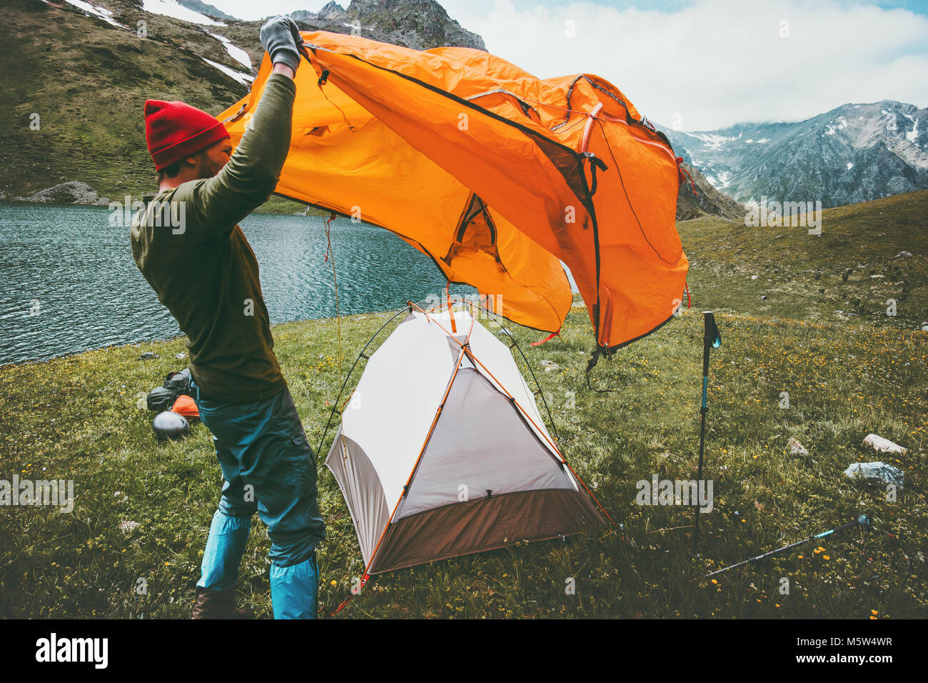 Man Traveler pitching tent camping gear outdoor Travel adventure ...