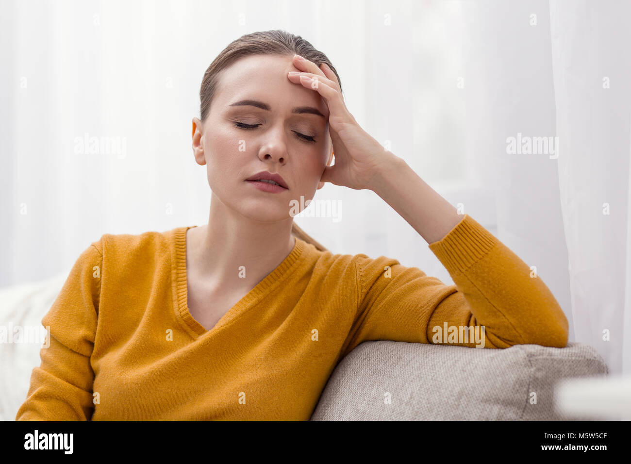 Beautiful concerned woman experiencing headache Stock Photo - Alamy