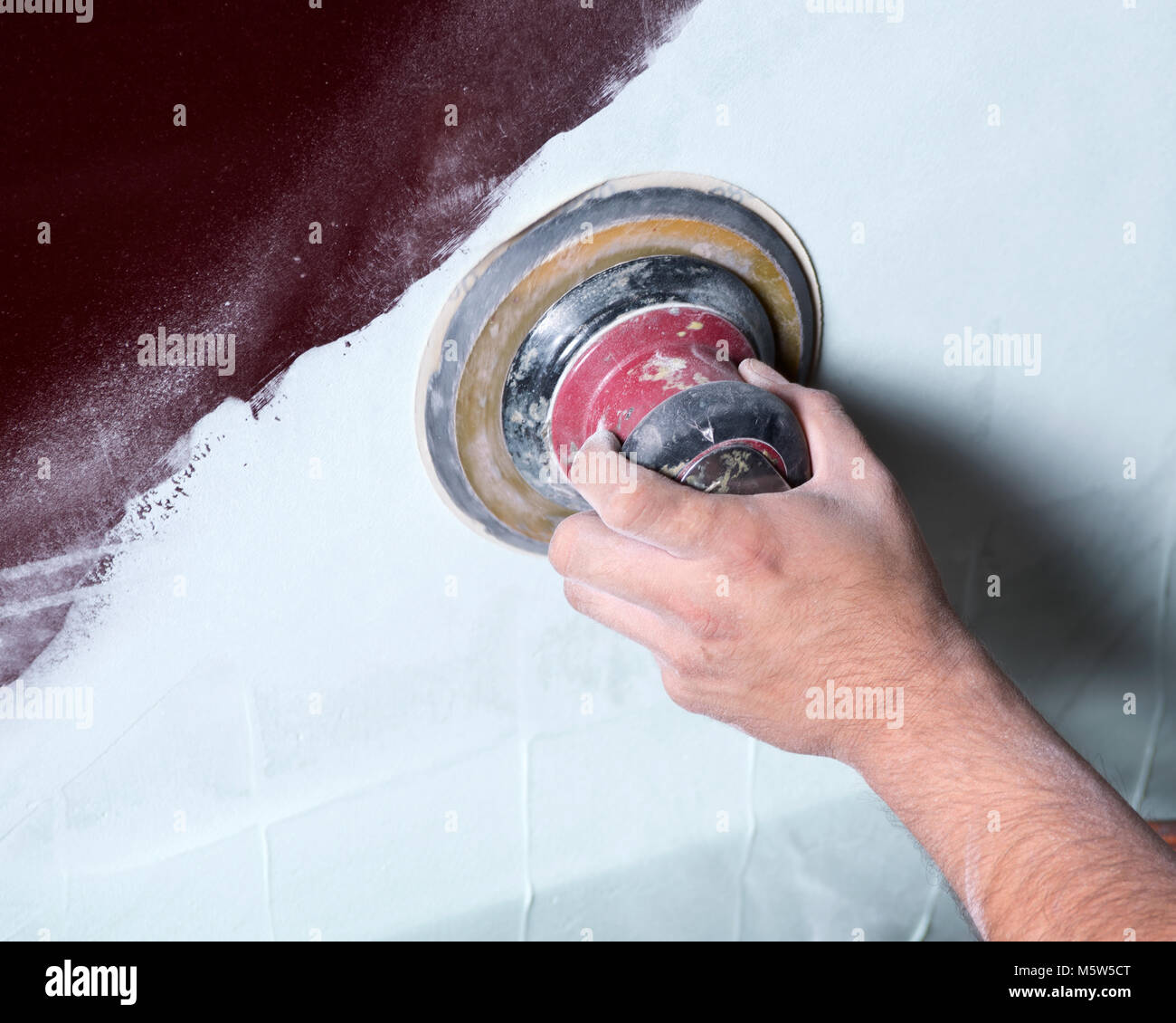 Worker is sanding filler with air sander in auto body shop Stock Photo ...