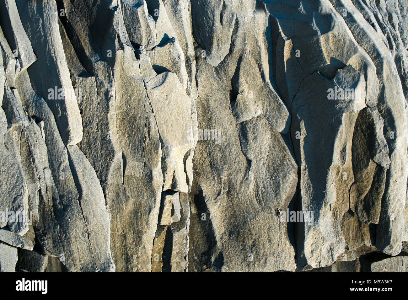 Close-up a gray-brown large weathered stony clump of mountain slate ...