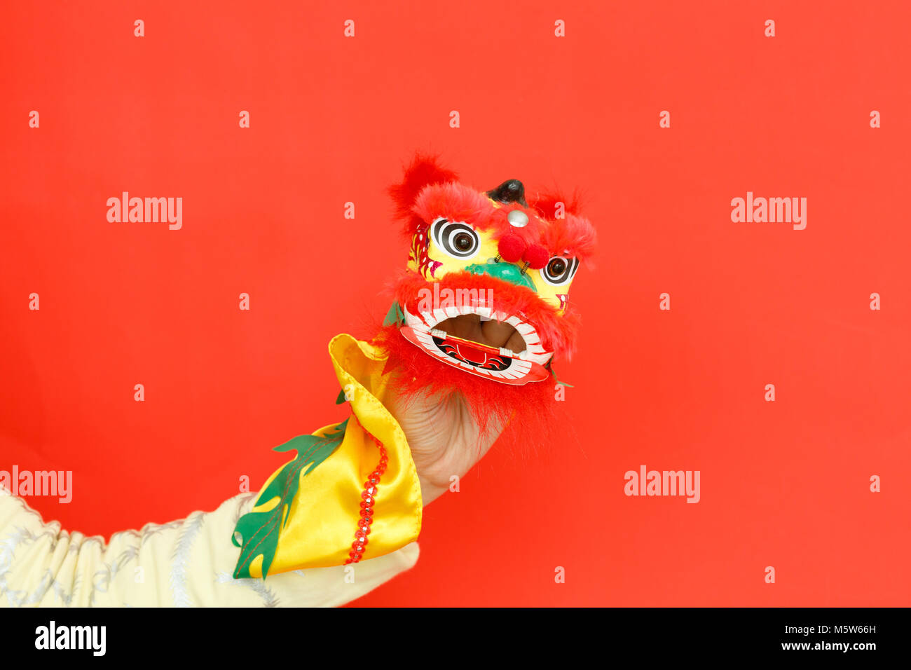 A hand manipulated Chinese style tiger puppets on the red background ...