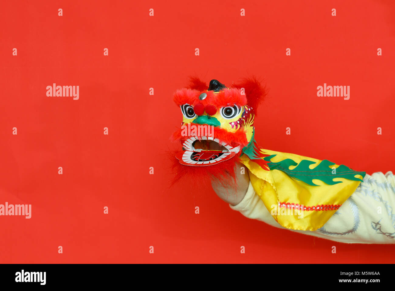 A hand manipulated Chinese style tiger puppets on the red background ...