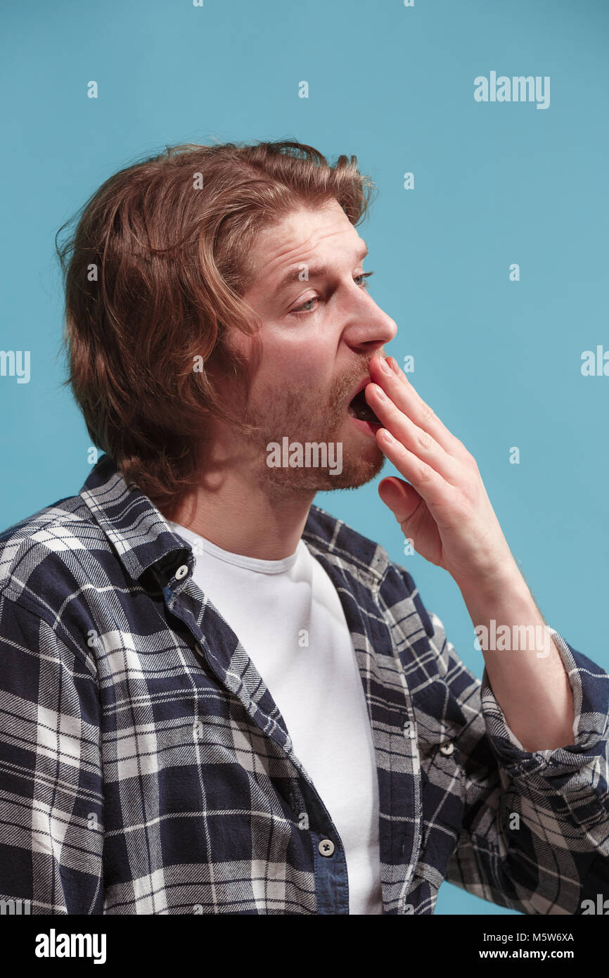 Beautiful bored man bored isolated on blue background Stock Photo - Alamy