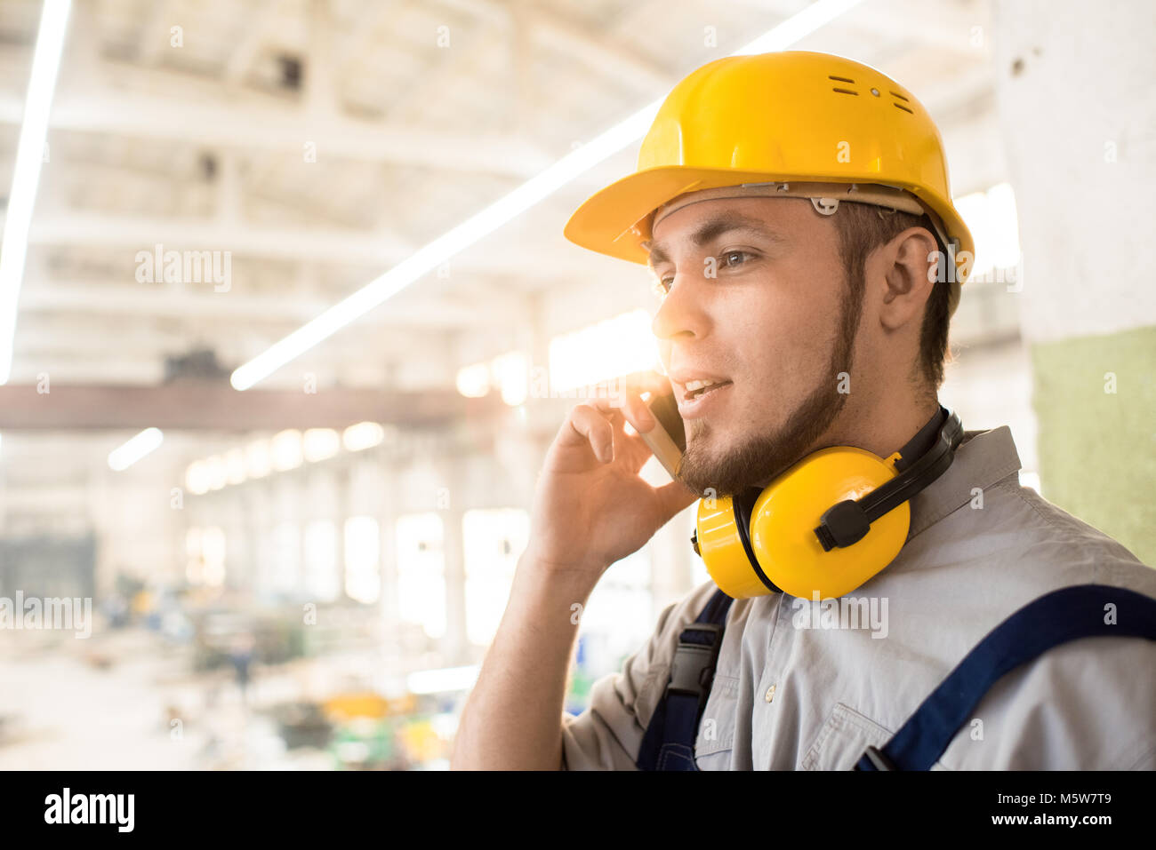 Head and shoulders portrait of handsome bearded worker wearing hardhat ...